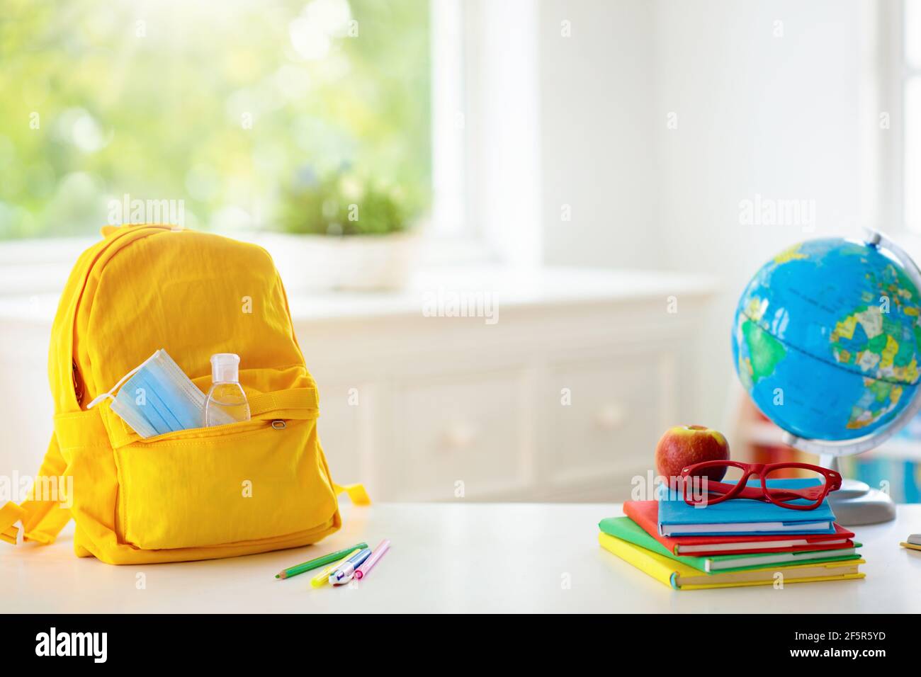 Backpack of school child with face mask and sanitizer. Student safety ...