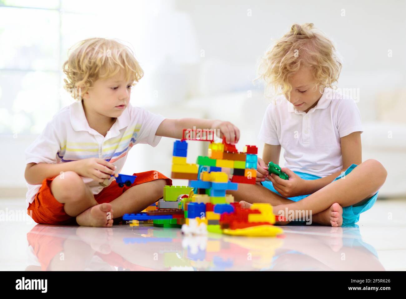 Child playing with colorful toy blocks. Kids play with plastic bricks ...