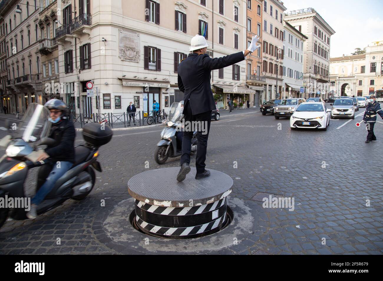 Rome, Italy. 26th Mar, 2021. A traffic policeman directs traffic from ...