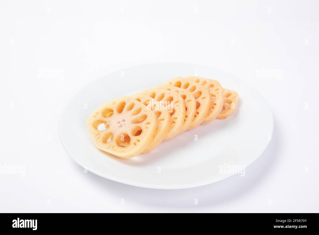 Closeup shot of lotus root slices on the plate isolated on white ...