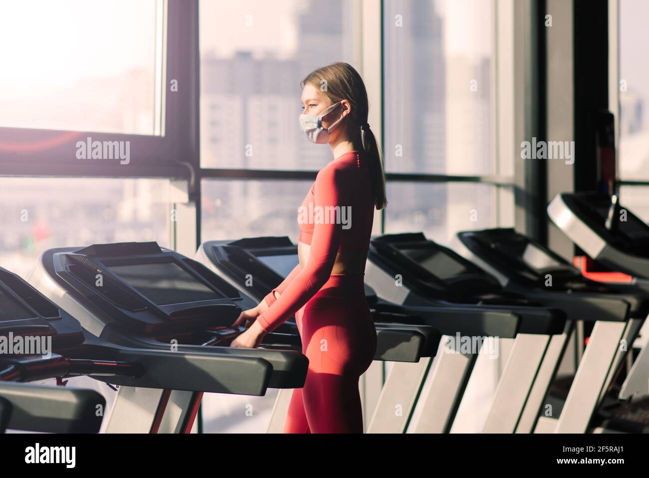 Woman wearing face mask exercise workout in gym during corona virus ...