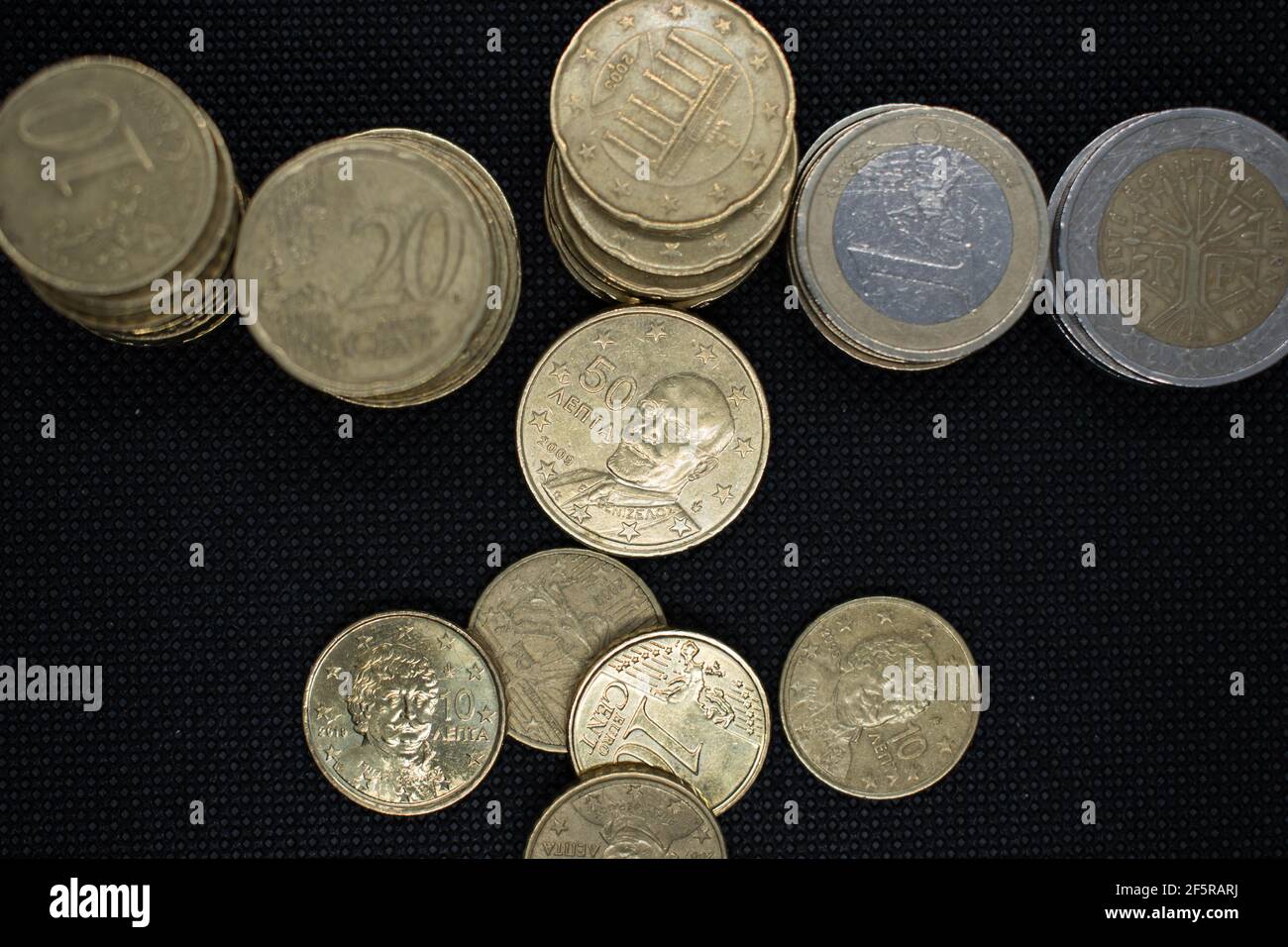 Euro Coins stacks on black background in different positions.Euro coins ...
