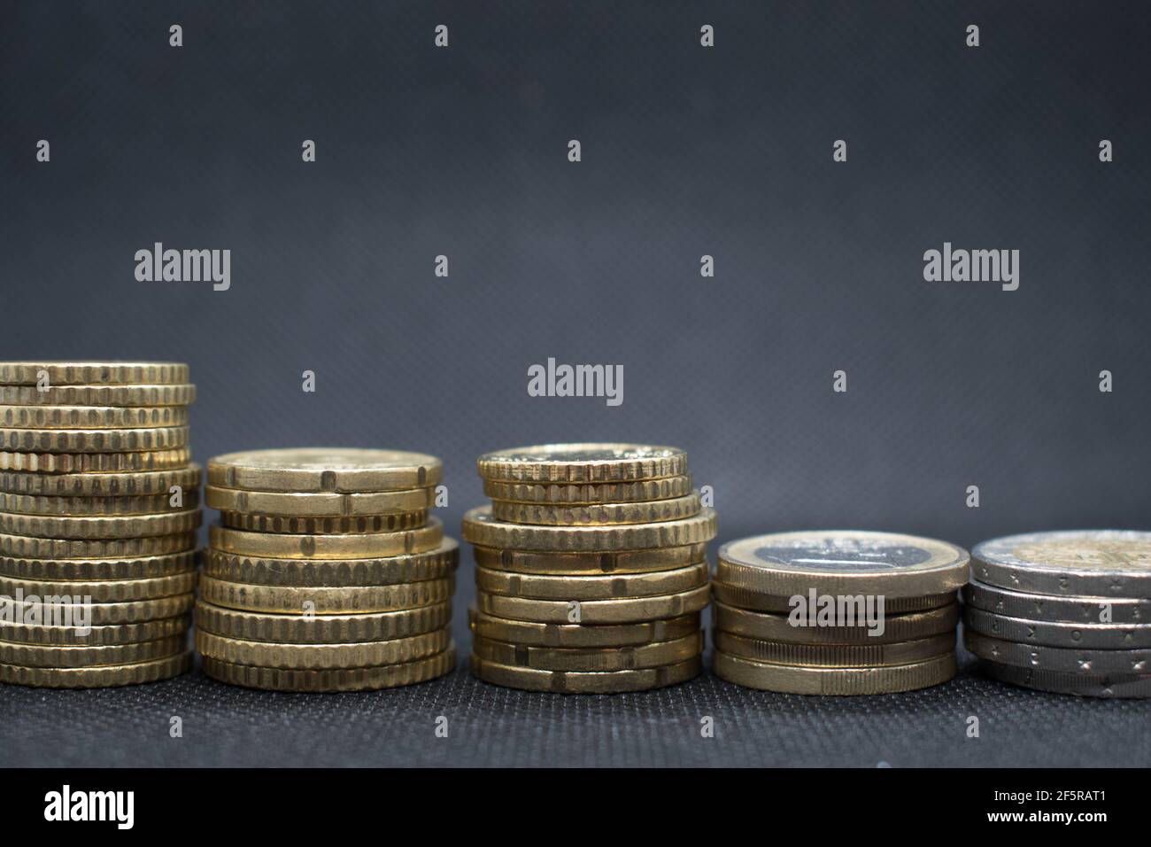 Euro Coins stacks on black background in different positions.Euro coins ...