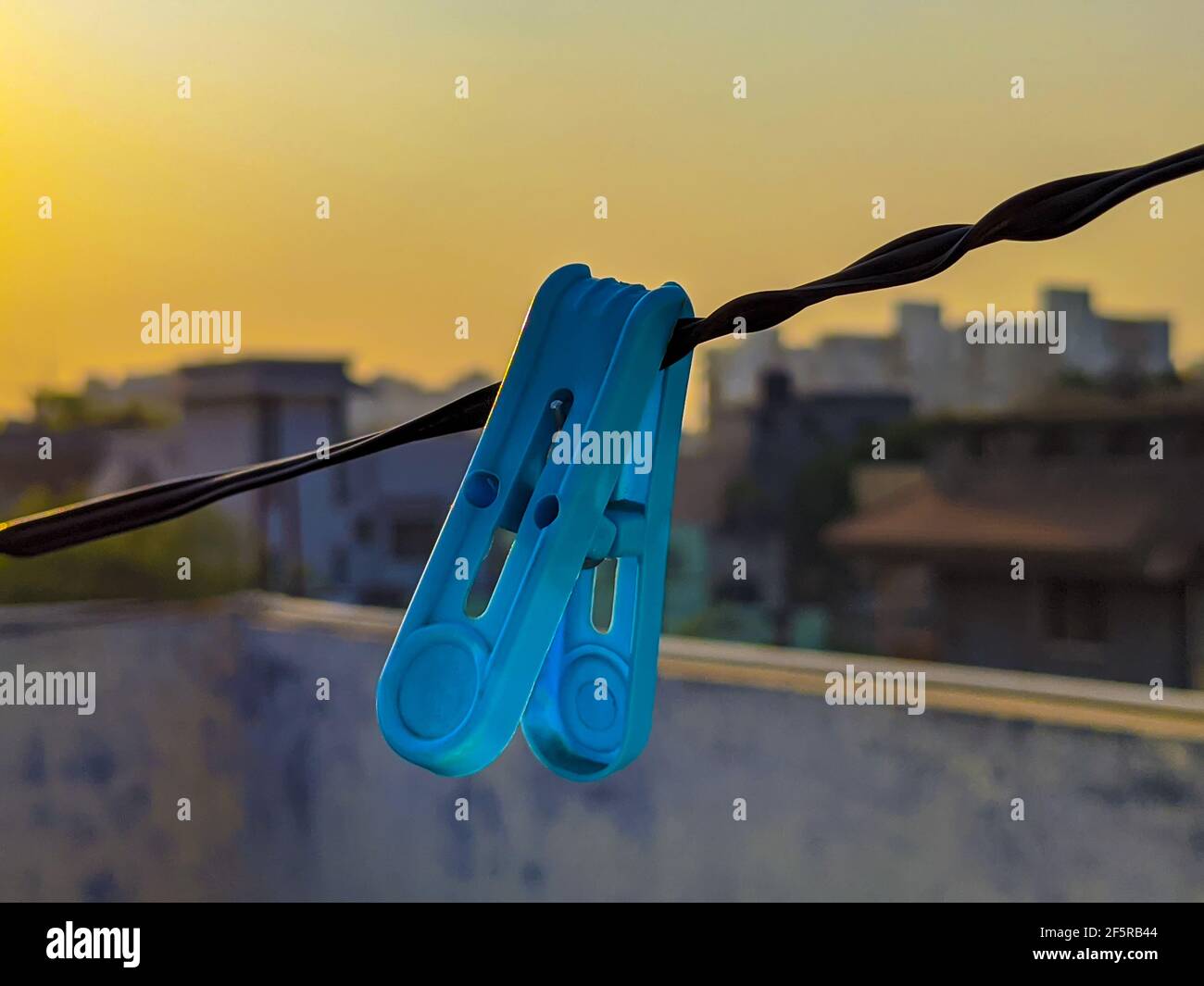 Blue clothespin hanging on the wire outdoors Stock Photo - Alamy