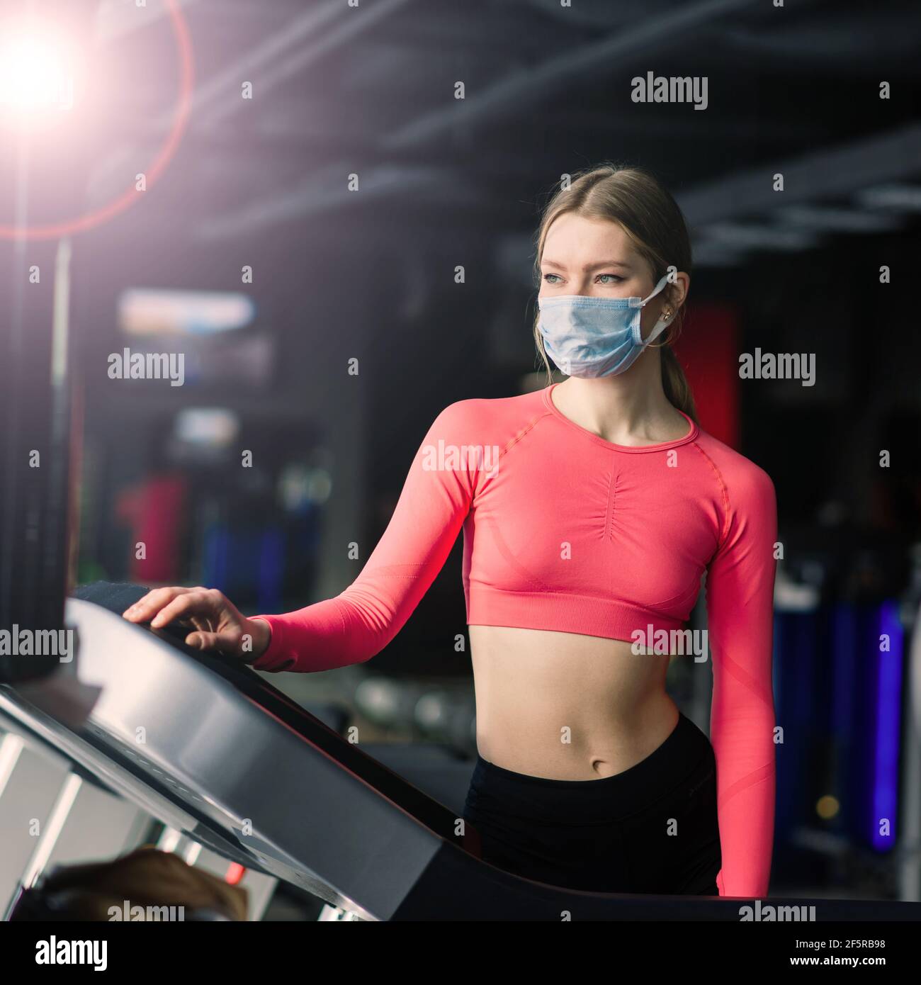 Woman wearing face mask exercise workout in gym during corona virus ...