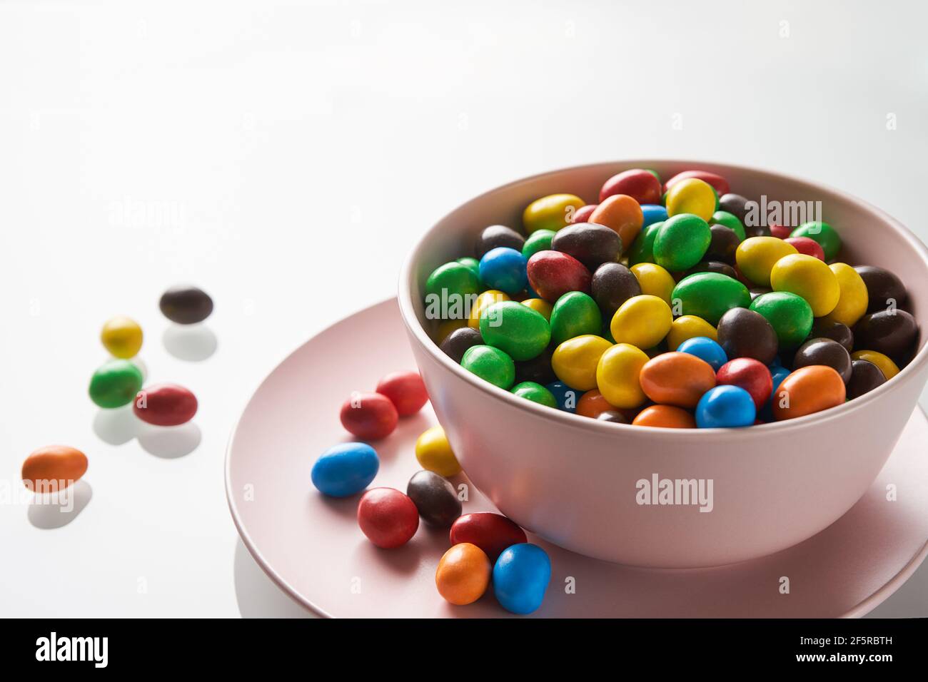 Bright candy drops in a pink bowl. Festive mood Stock Photo - Alamy