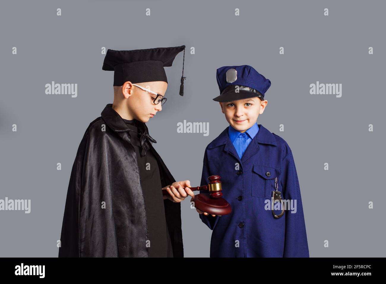 Children in costume of policeman and judge. Boys dream about future ...