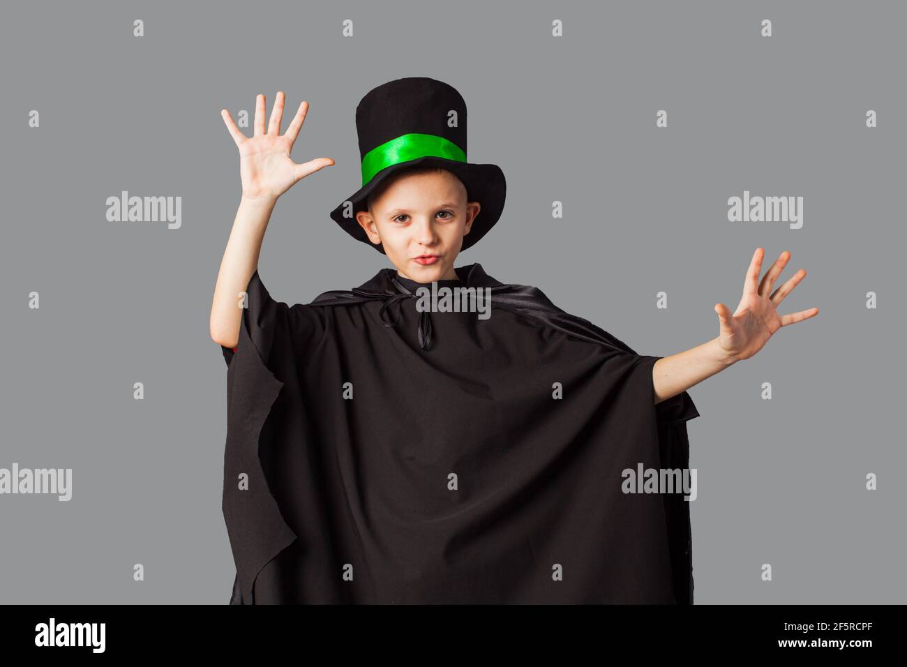 Young magician performing a trick. Little boy wearing top-hat and black ...
