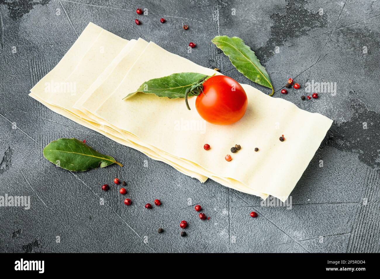 Organic lasagna pasta sheets set, with seasoning and herb, on gray ...