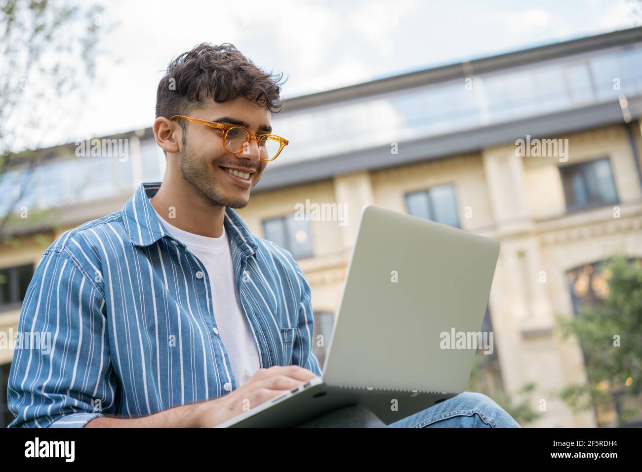 Portrait Of Happy Indian Programmer Using Laptop Computer Working Freelance Project Online