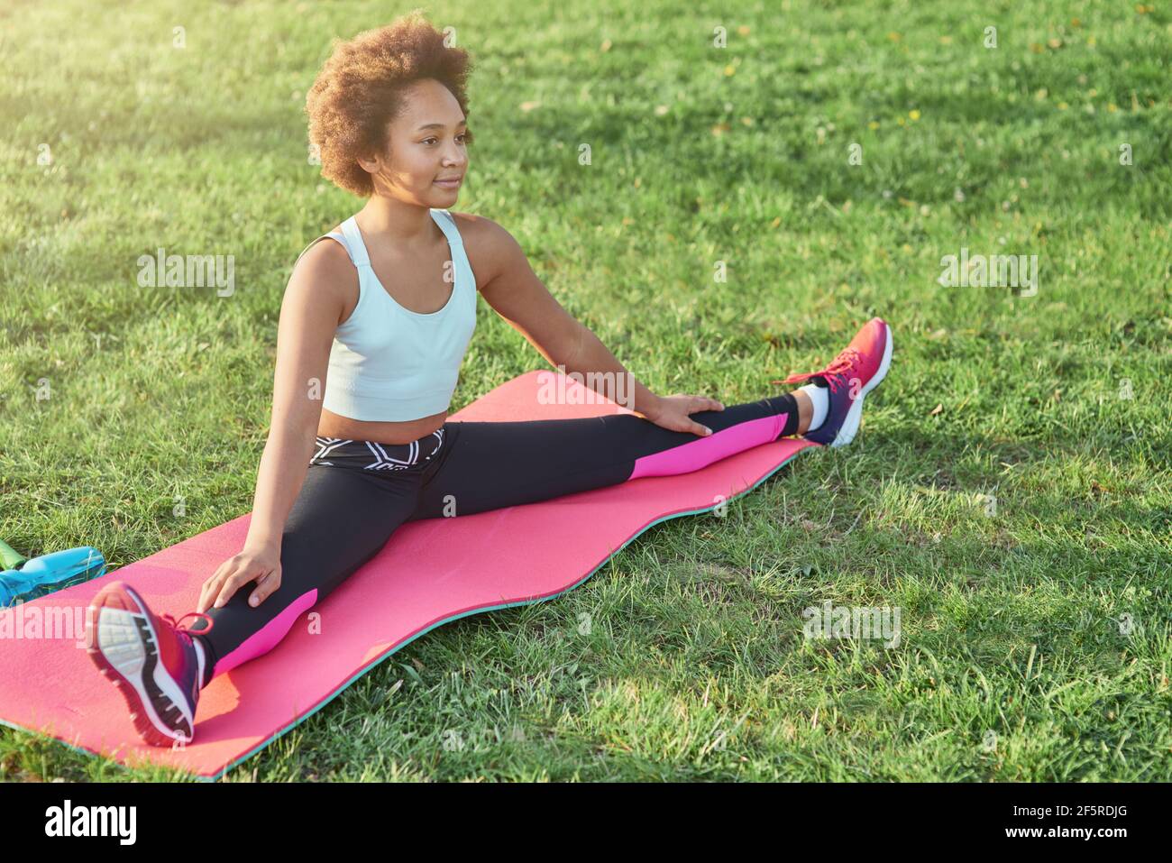 Cute female child doing the splits in park Stock Photo - Alamy