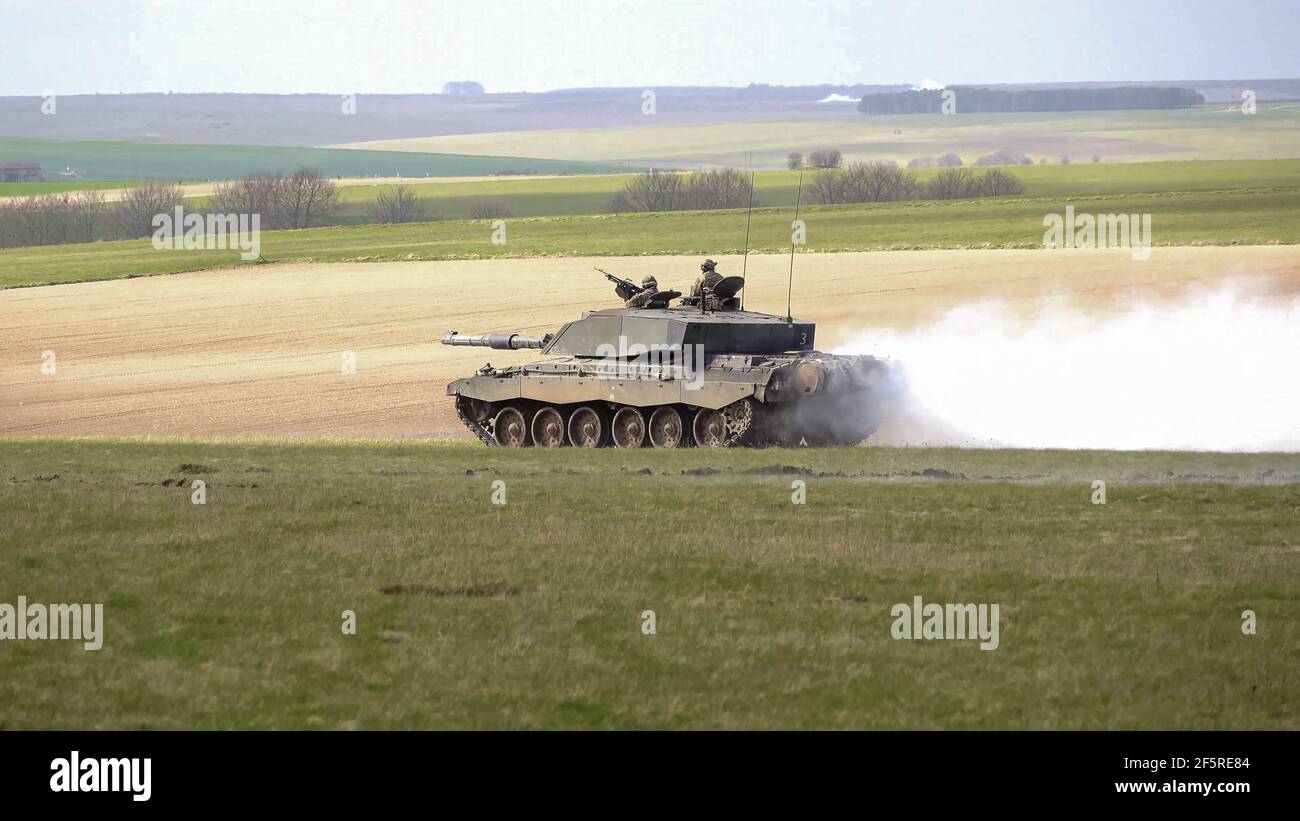 a British Army Challenger 2 II main battle tank creating a thick white ...
