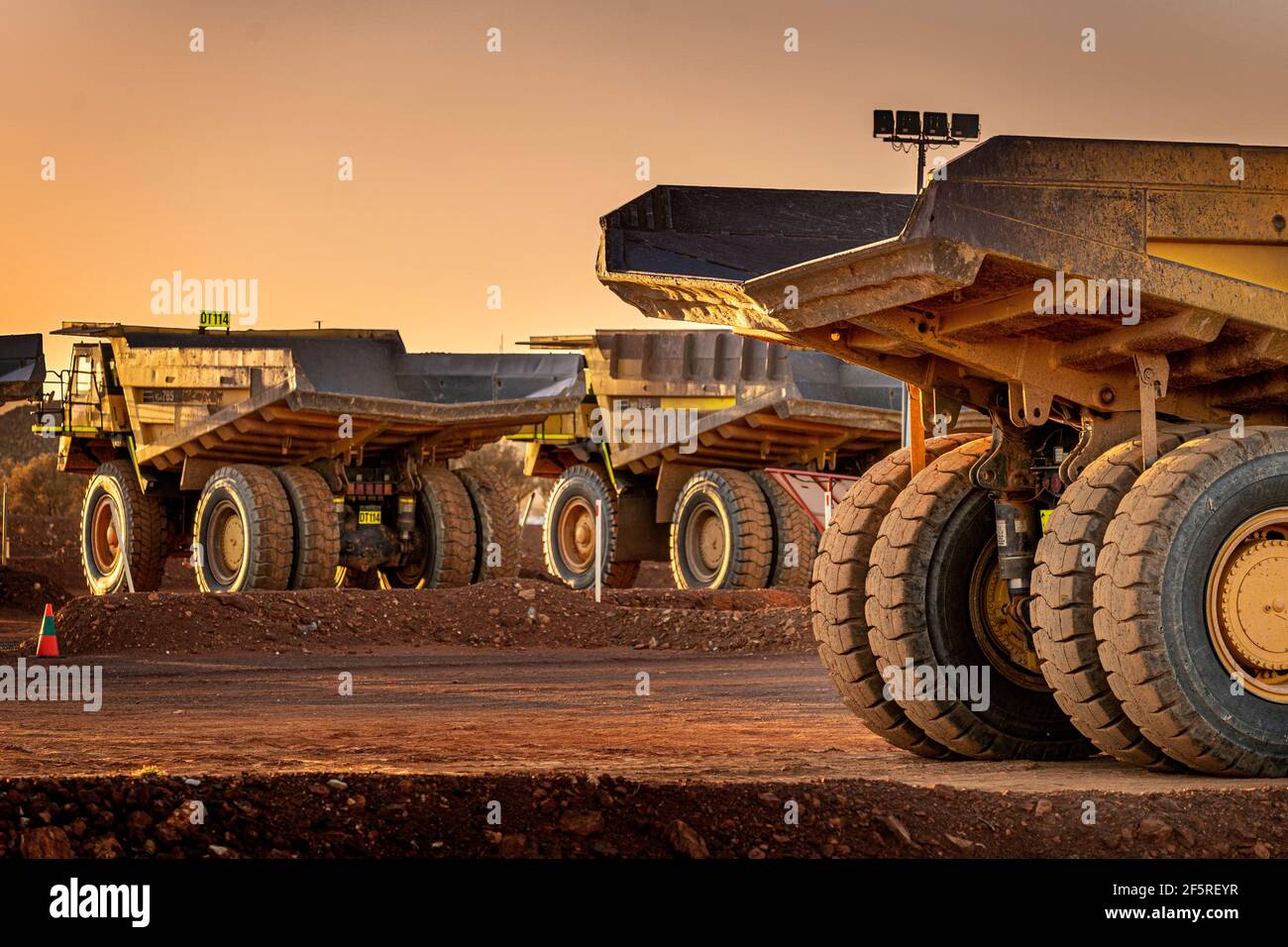 Dump trucks at sunset on mining Go Line in open pit mining area Stock ...