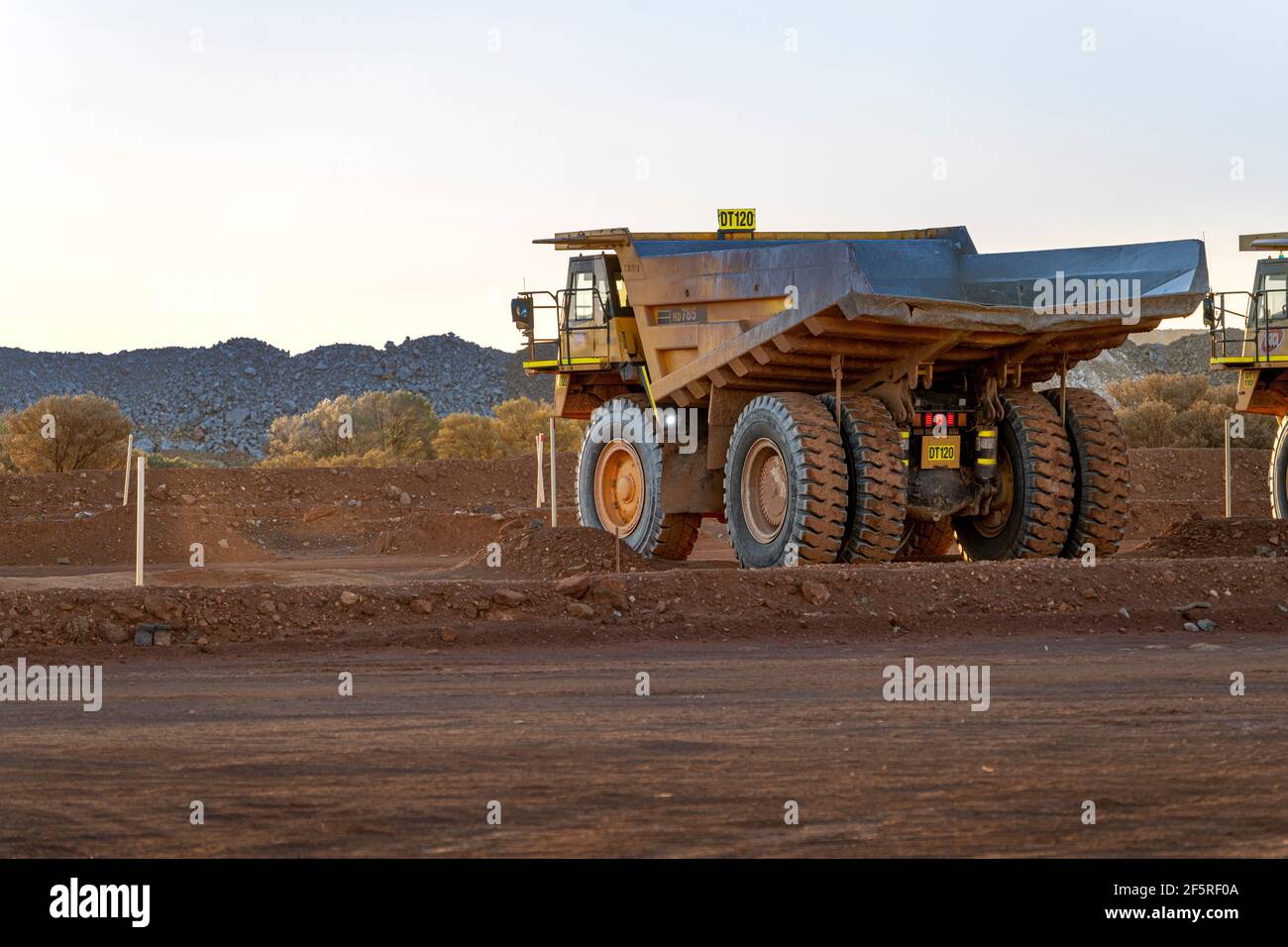 Dump trucks at sunset on mining Go Line in open pit mining area Stock ...
