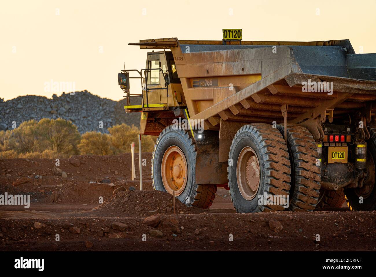 Dump trucks at sunset on mining Go Line in open pit mining area Stock ...