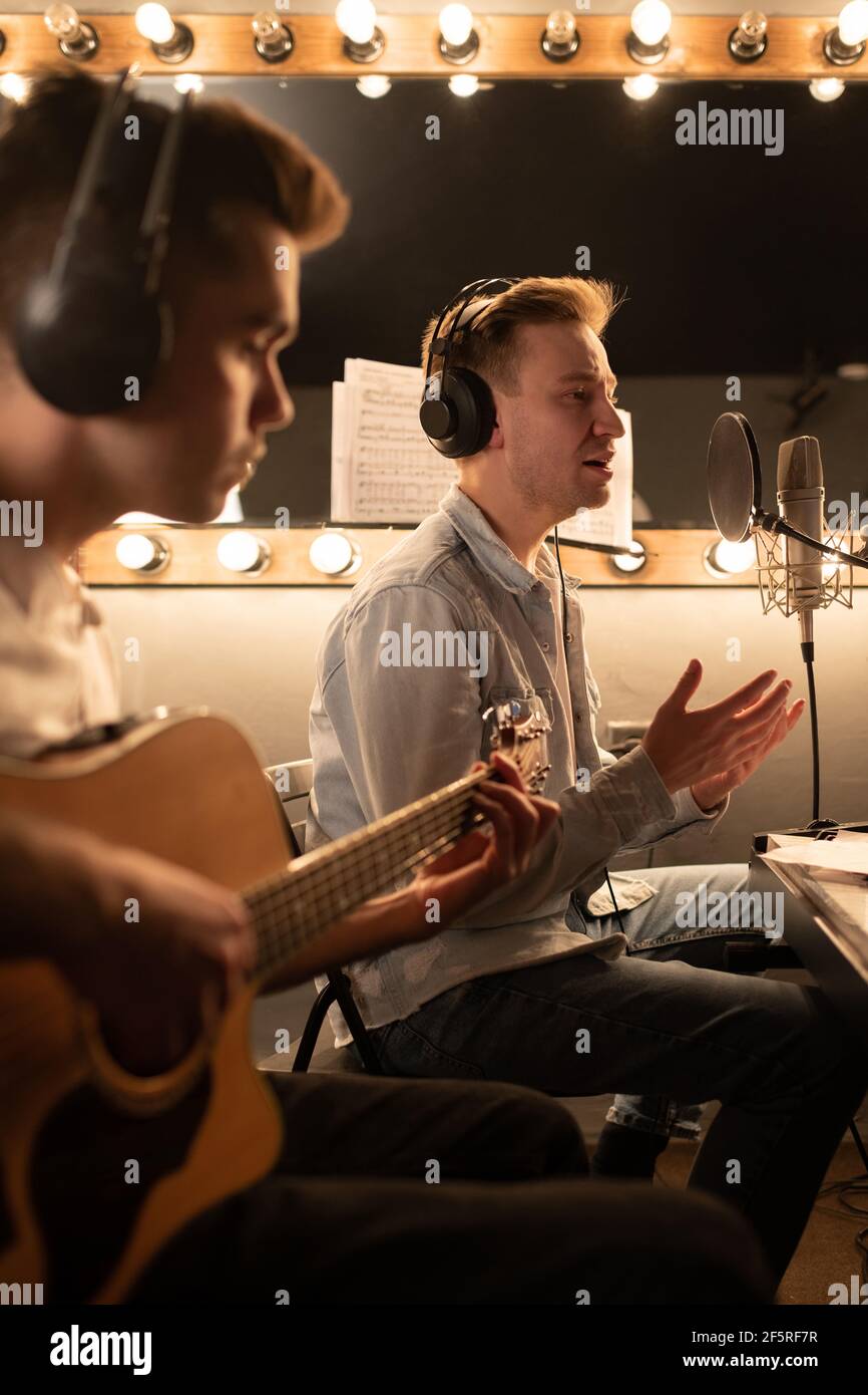 Men recording guitar song in studio Stock Photo - Alamy