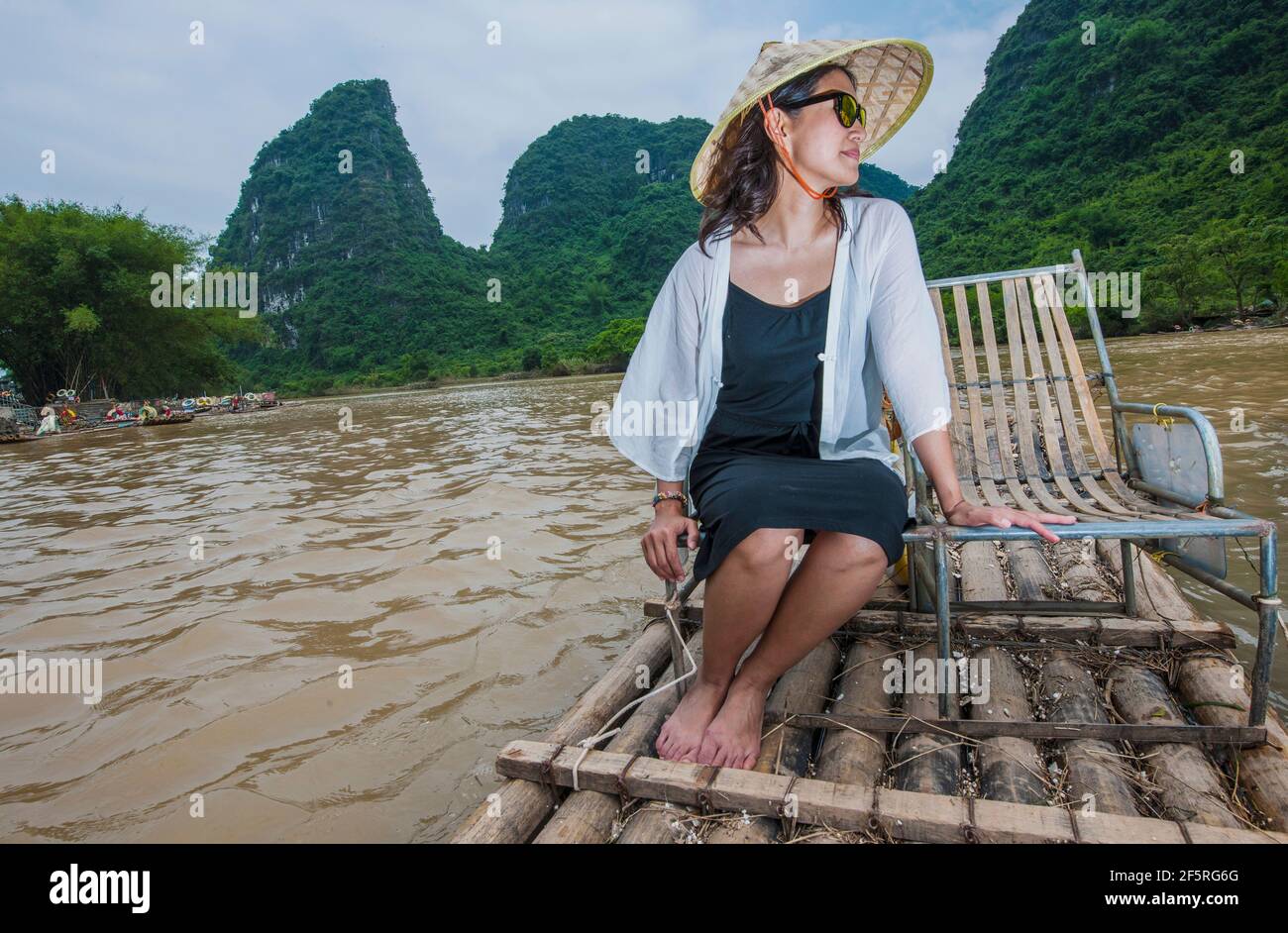 woman in traditional Asian sitting on bamboo raft in Yangshuo Stock ...