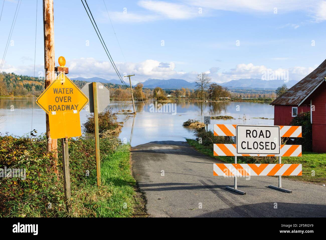 Multiple signs warning of flooding on country road in the Snoqualmie ...