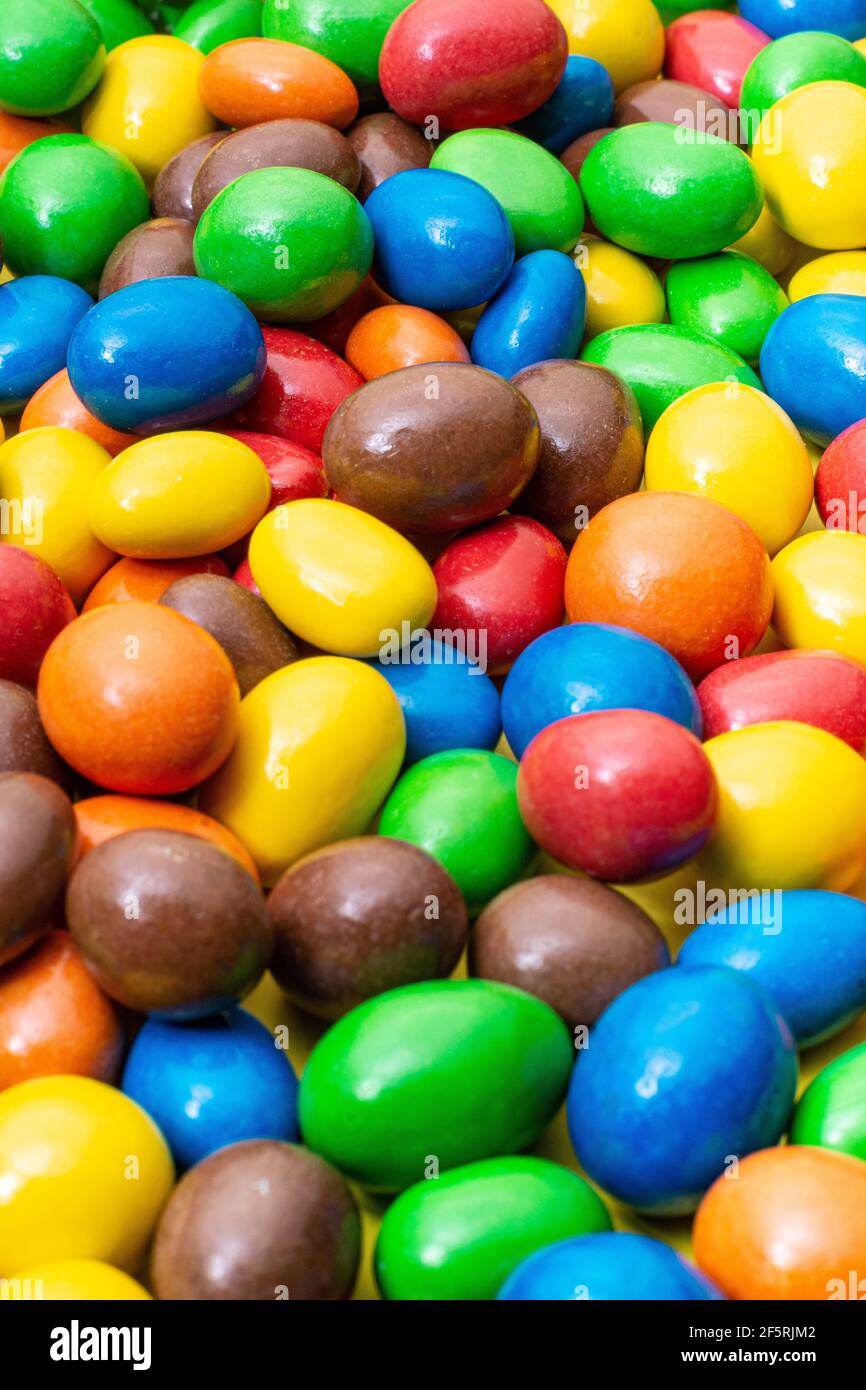 colored crunchy chocolate balls occupying the entire image vertically ...