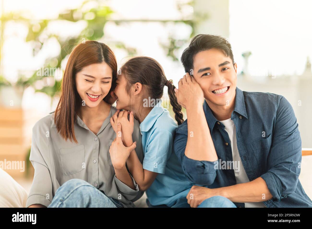 Happy family and child whispering gossip Stock Photo - Alamy