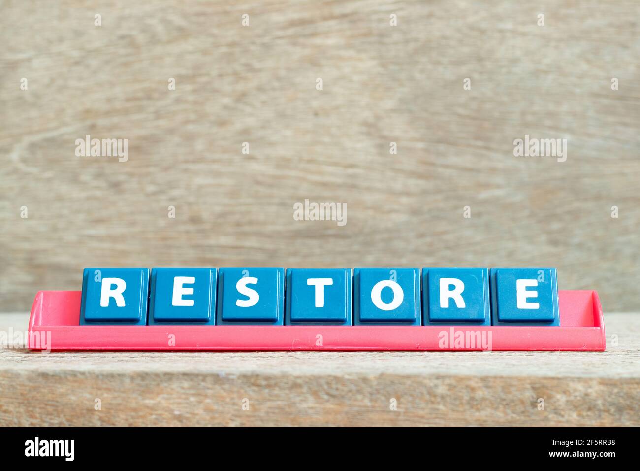 Tile alphabet letter with word restore in red color rack on wood ...