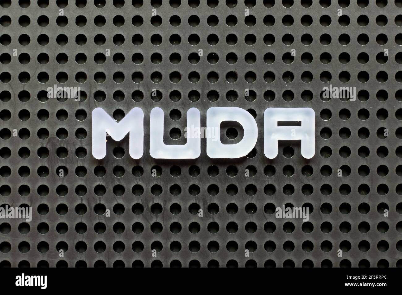 White color letter in word muda on black pegboard background Stock ...