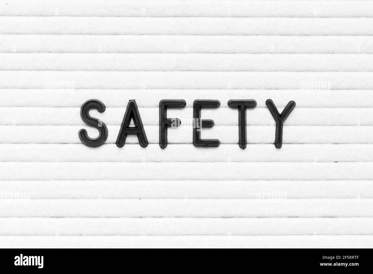 Black color letter in word safety on white felt board background Stock ...