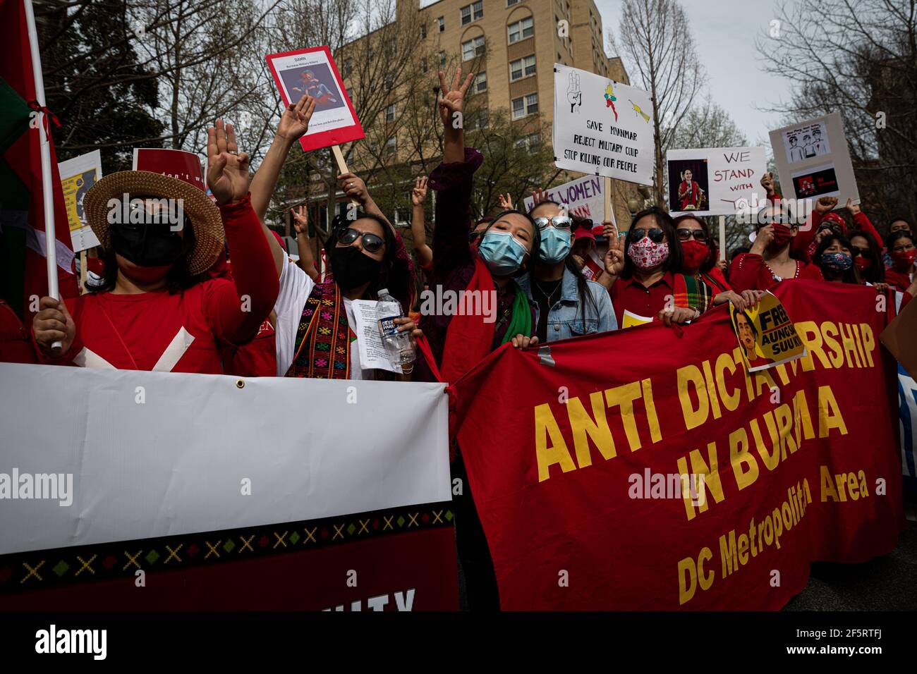 Burmese-Americans flash a three-finger solidarity salute during a rally ...
