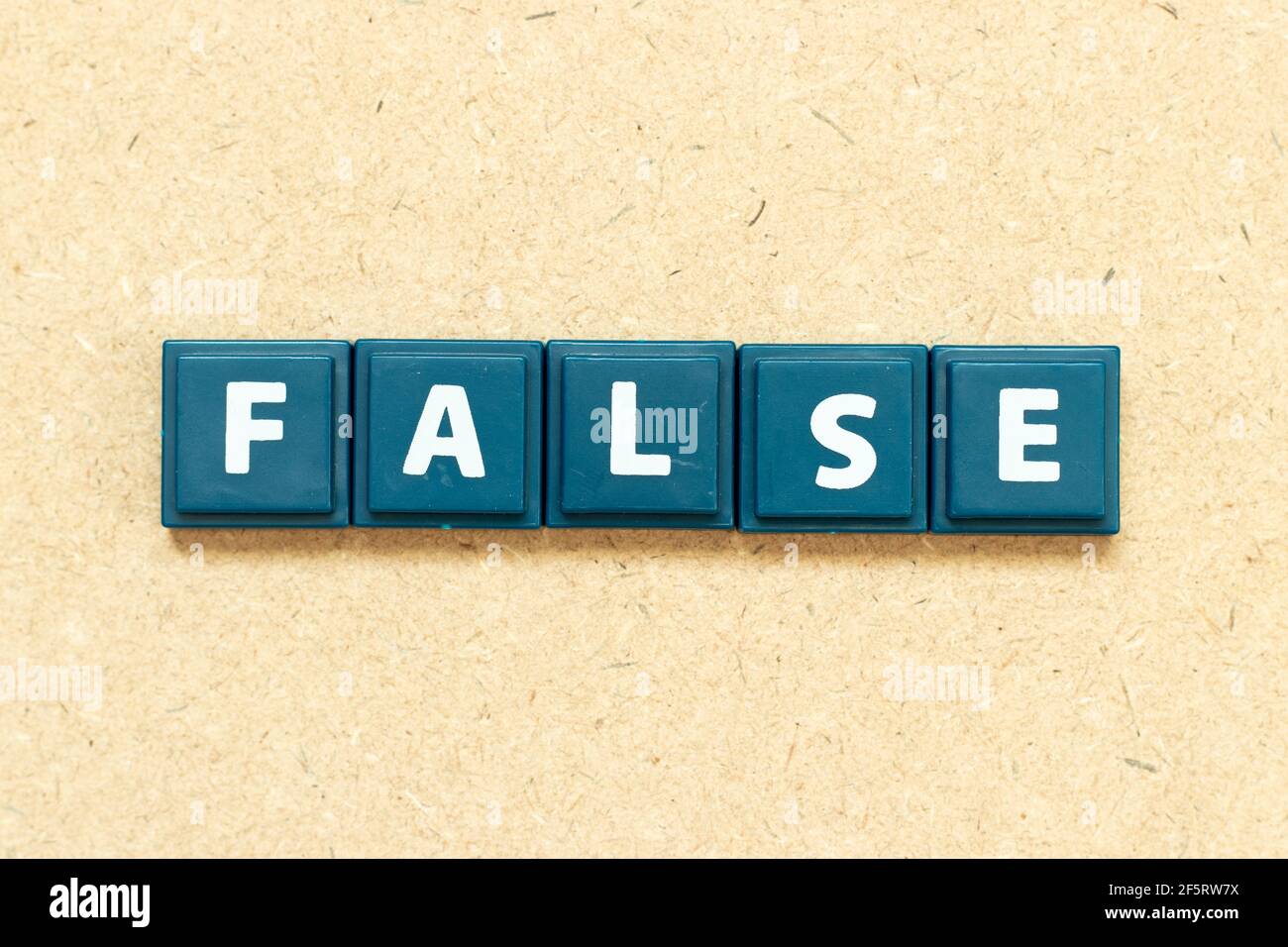 Tile alphabet letter in word false on wood background Stock Photo - Alamy