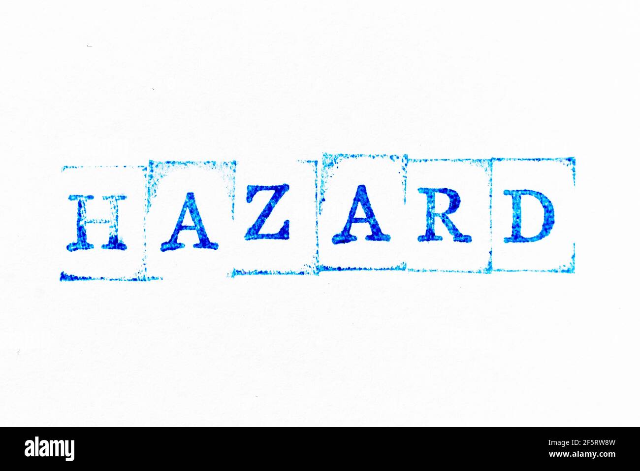 Blue color ink rubber stamp in word hazard on white paper background ...
