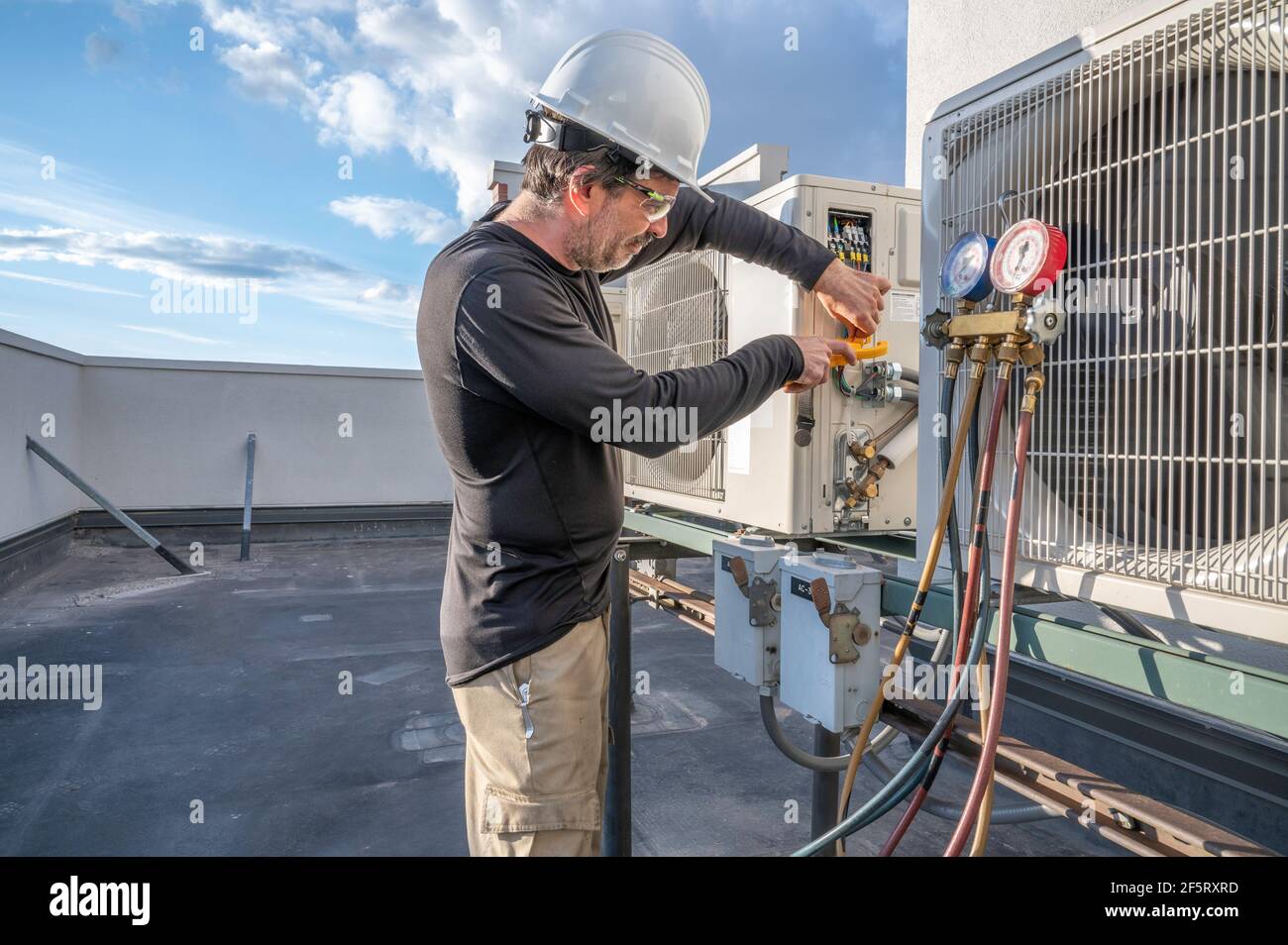 HVAC tech checking a mini split air conditioner amps with a meter Stock ...