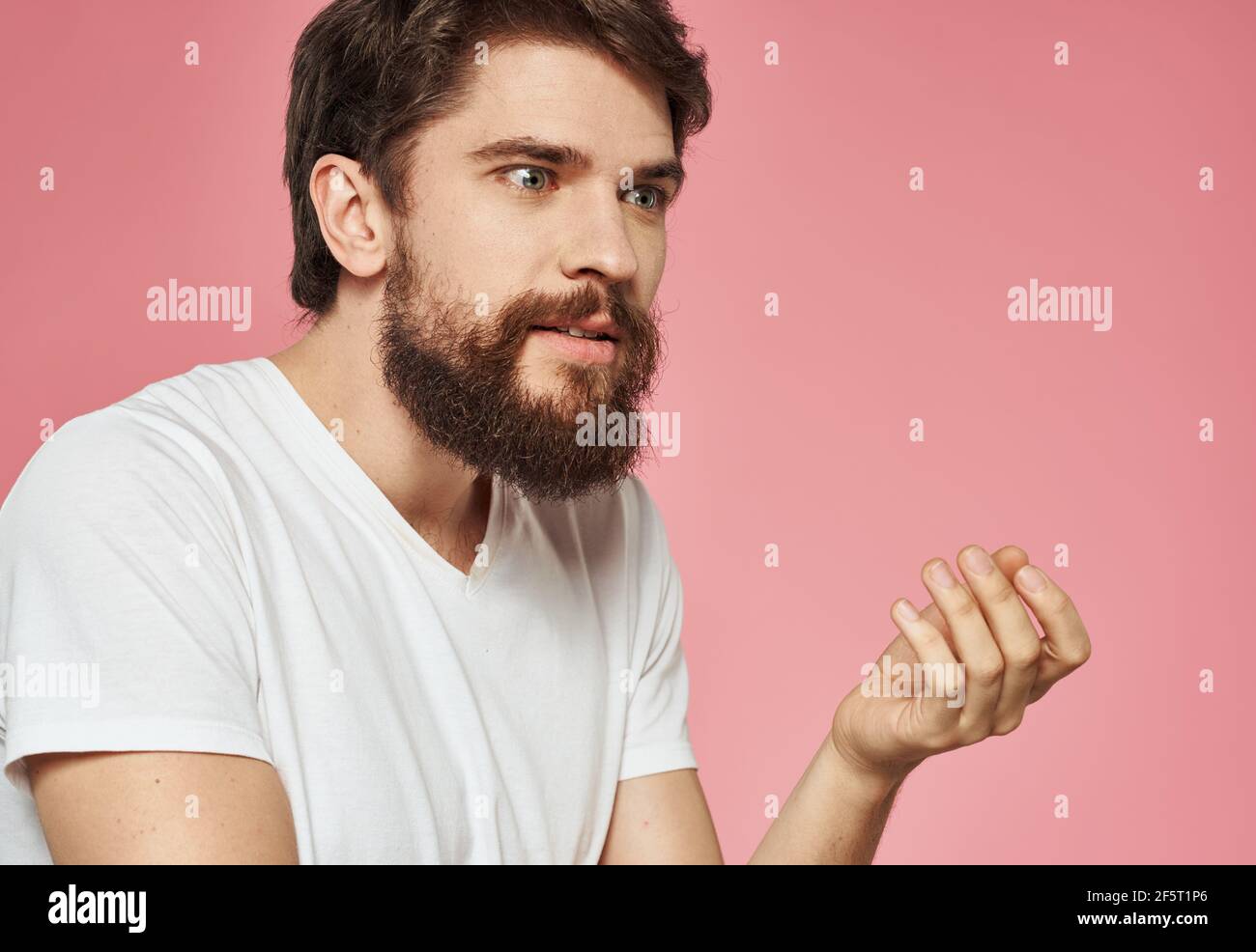 Puzzled man gesturing with hands side view pink background Stock Photo ...