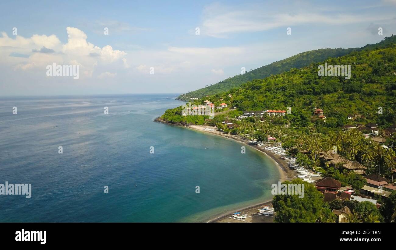 Aerial photo of a wild beach in Bali. A long strip of beach and a steep ...