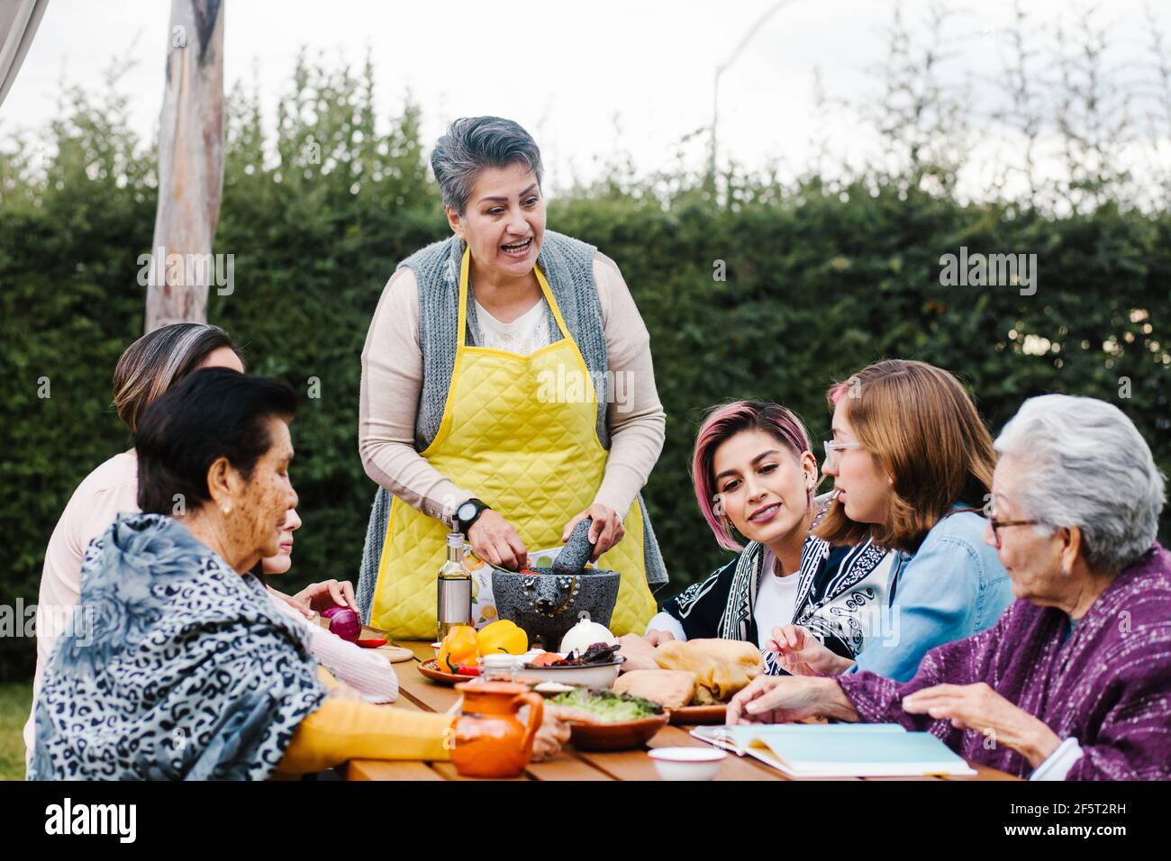 latin grandmother and granddaughter, daughter cooking mexican food at ...
