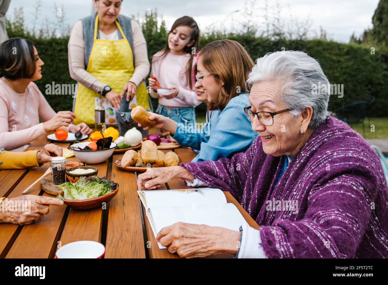 latin grandmother and granddaughter, daughter cooking mexican food at ...