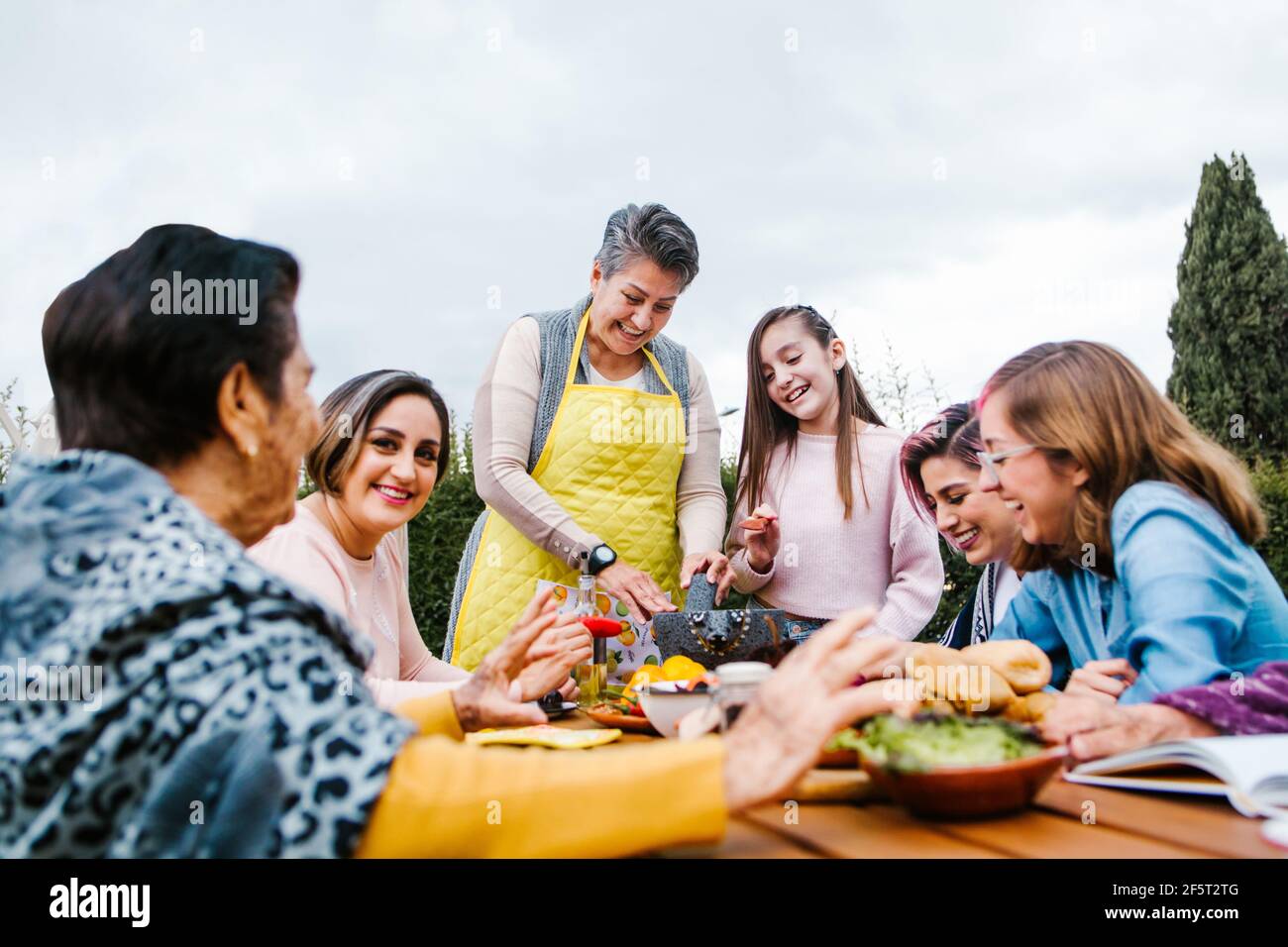 latin grandmother and granddaughter, daughter cooking mexican food at ...
