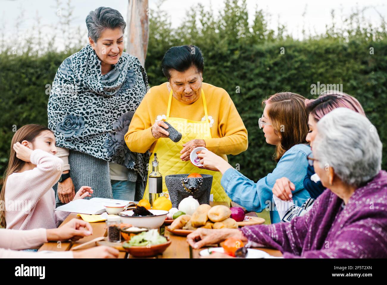 latin grandmother and granddaughter, daughter cooking mexican food at ...
