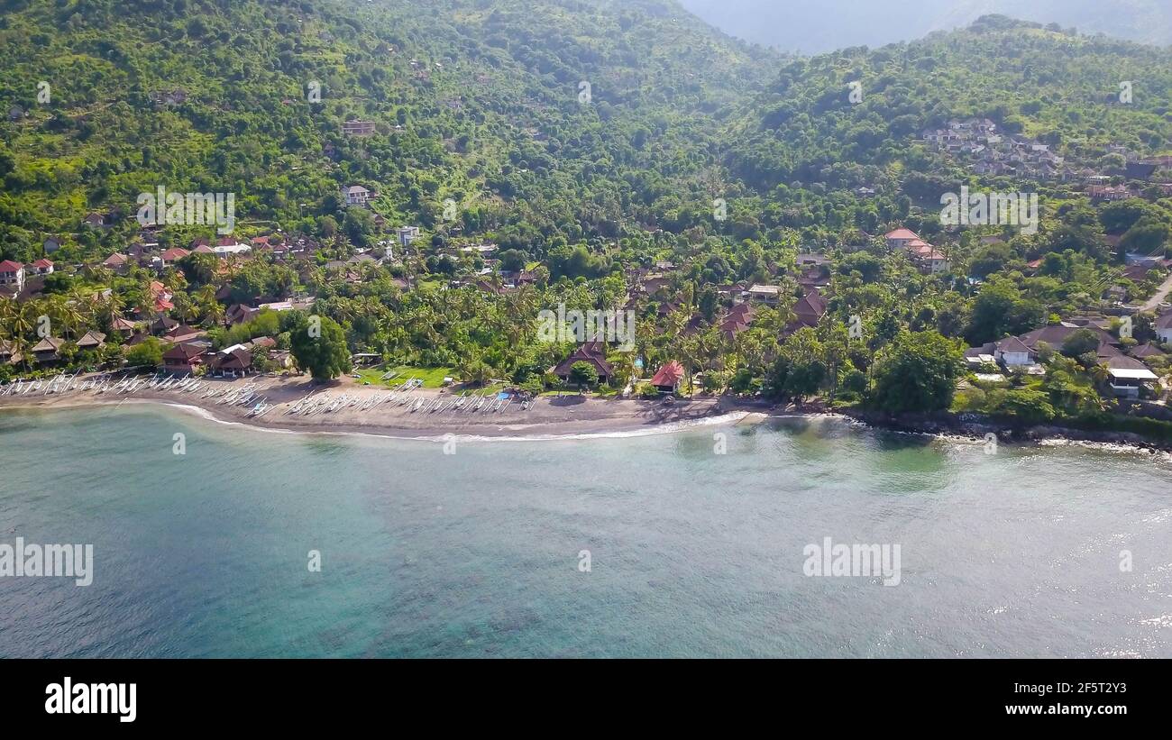 Aerial photo of a wild beach in Bali. A long strip of beach and a steep ...