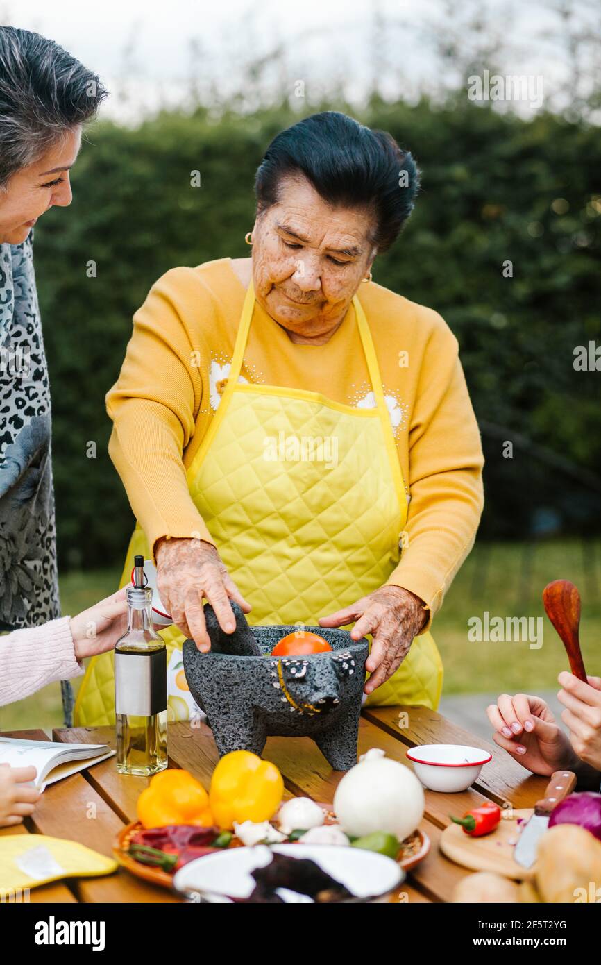 latin grandmother and granddaughter, daughter cooking mexican food at ...