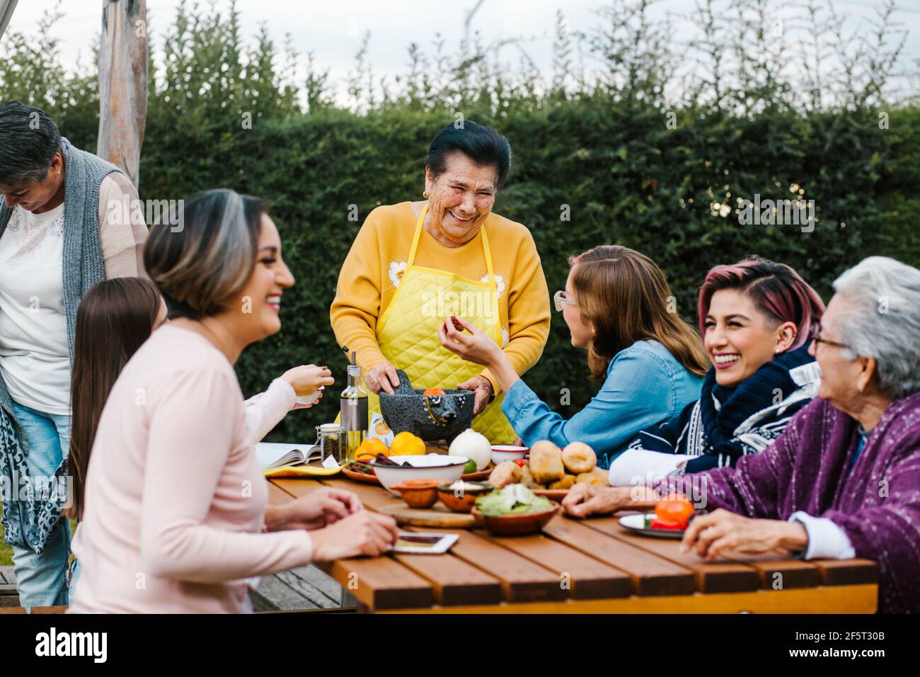 latin grandmother and granddaughter, daughter cooking mexican food at ...