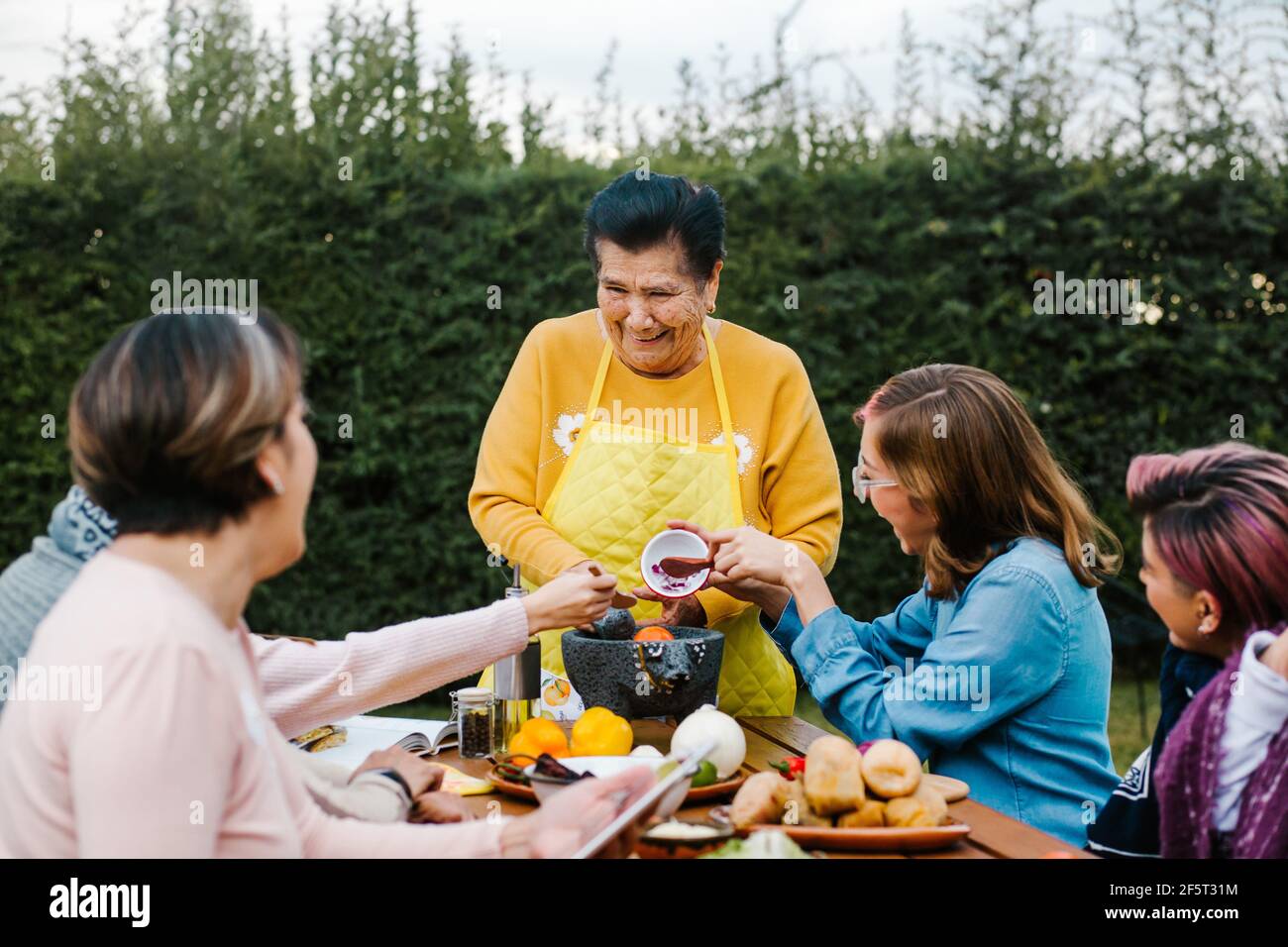 latin grandmother and granddaughter, daughter cooking mexican food at ...