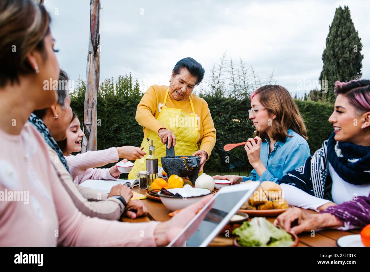latin grandmother and granddaughter, daughter cooking mexican food at ...