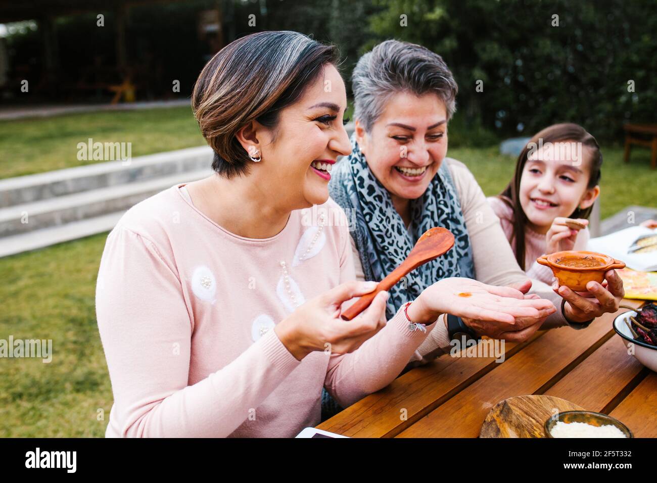 latin grandmother and granddaughter, daughter cooking mexican food at ...