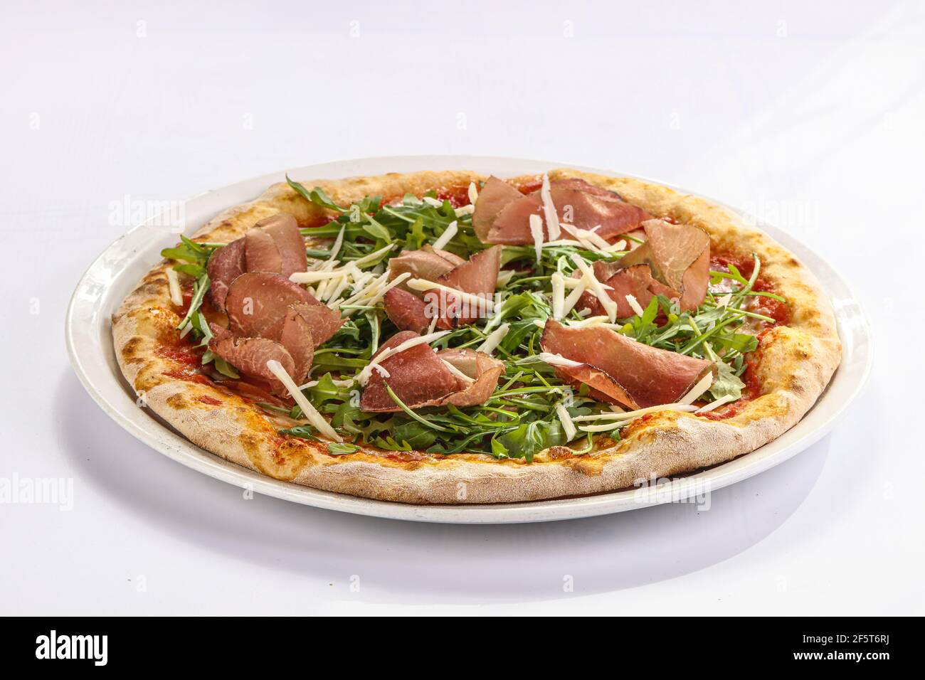Italian pizza with prosciutto, cheese and ruccola Stock Photo - Alamy