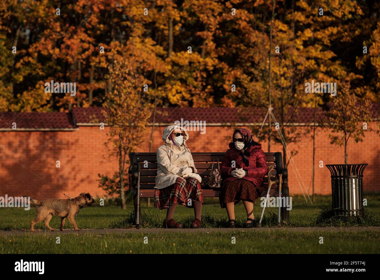 MOSCOW, RUSSIA - SEPTEMBER 27 2020: Masked grandmothers sit on a bench ...