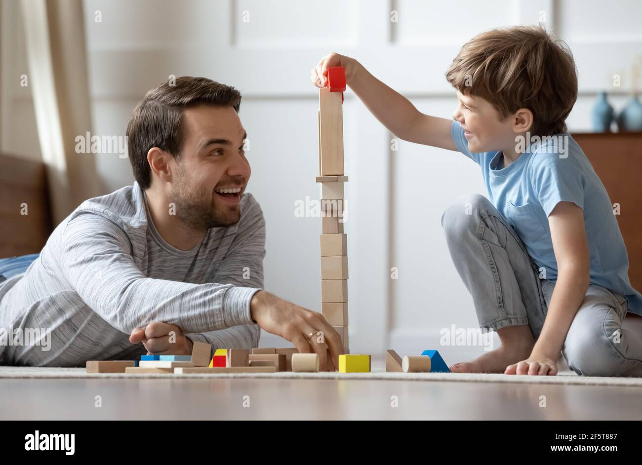 Happy young dad play build blocks with small son Stock Photo - Alamy