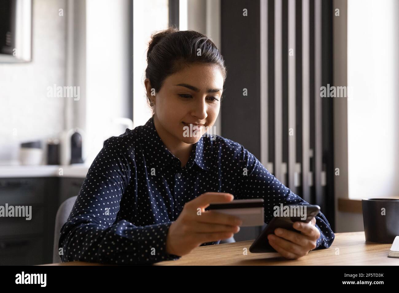 Close up smiling Indian woman paying online, using phone Stock Photo ...