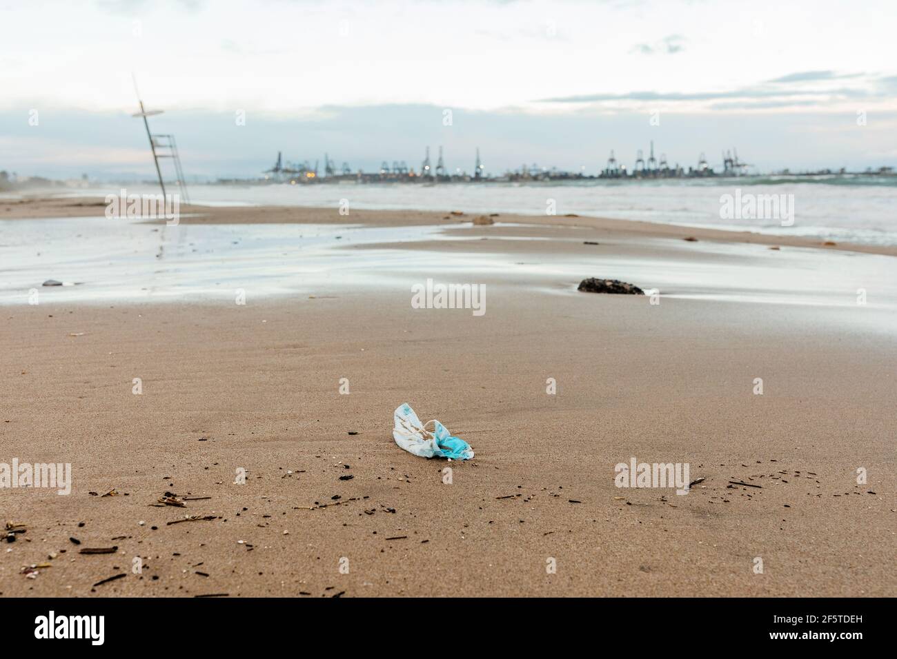 Dirty used medical masks on sandy beach showing concept of pollution ...