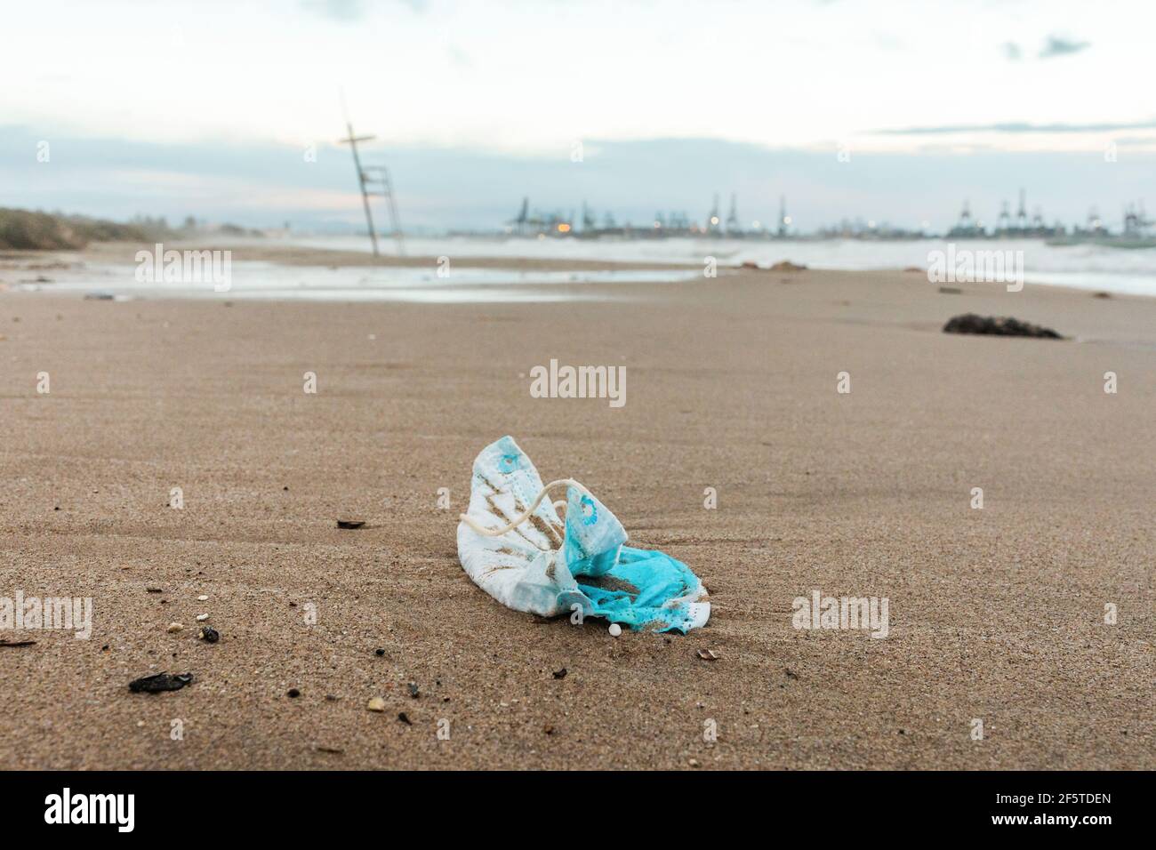Dirty used medical masks on sandy beach showing concept of pollution ...