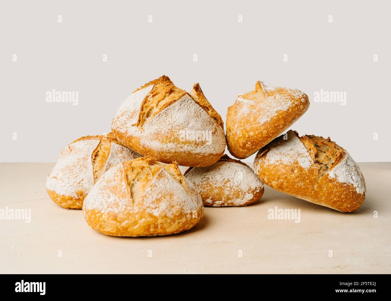 Delicious round shaped bread with flour on golden surface in bakery on ...